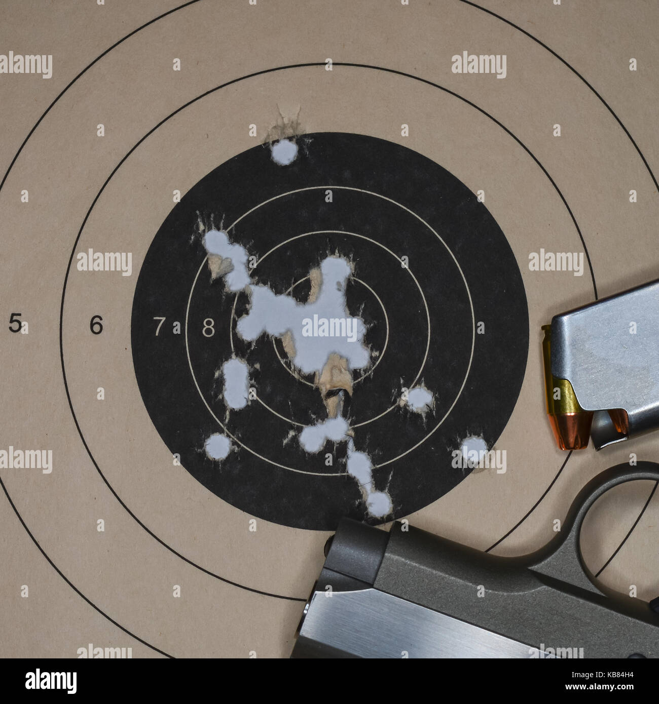 Results of target practice and a small pistol with magazine Stock Photo ...