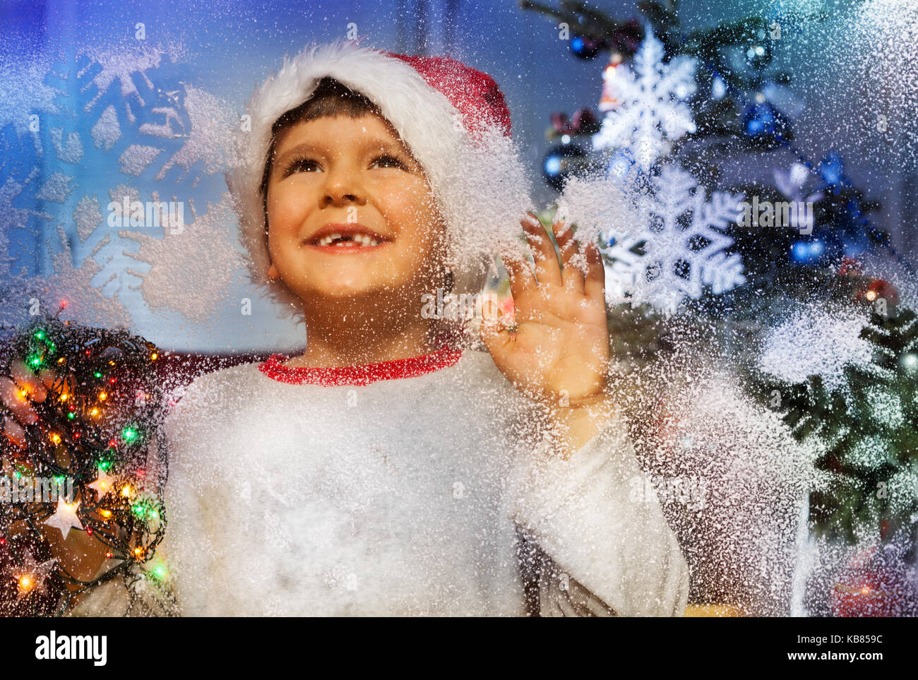 Little boy behind window with snowflake smiling Stock Photo - Alamy