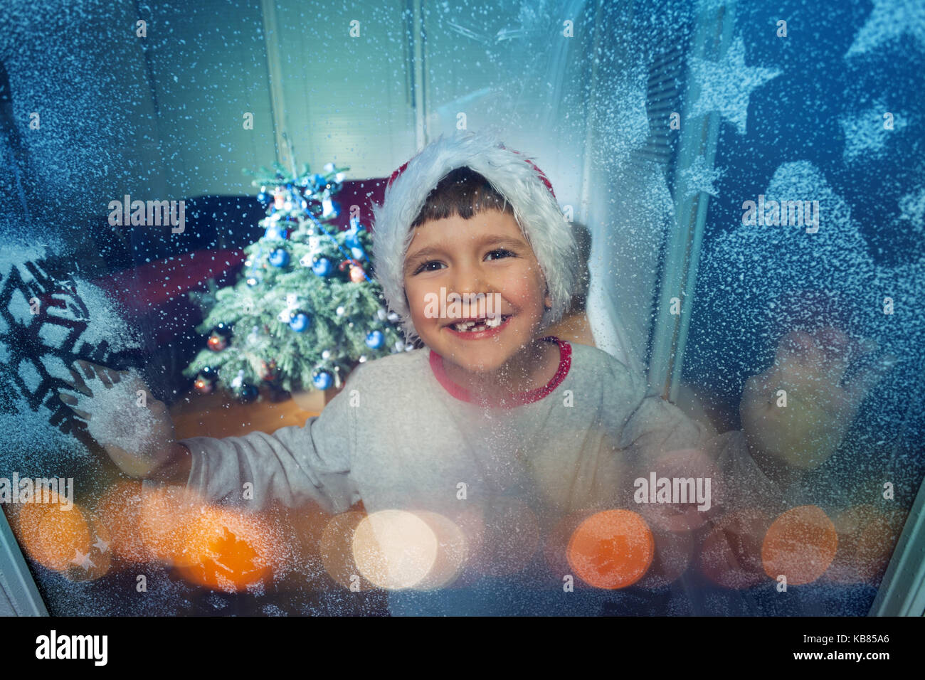 Little boy behind frozen window before Christmas Stock Photo - Alamy