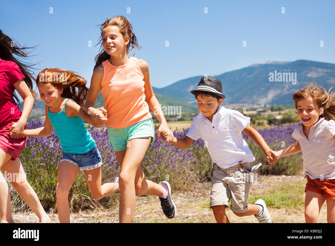 Happy children running together in lavender fields Stock Photo - Alamy