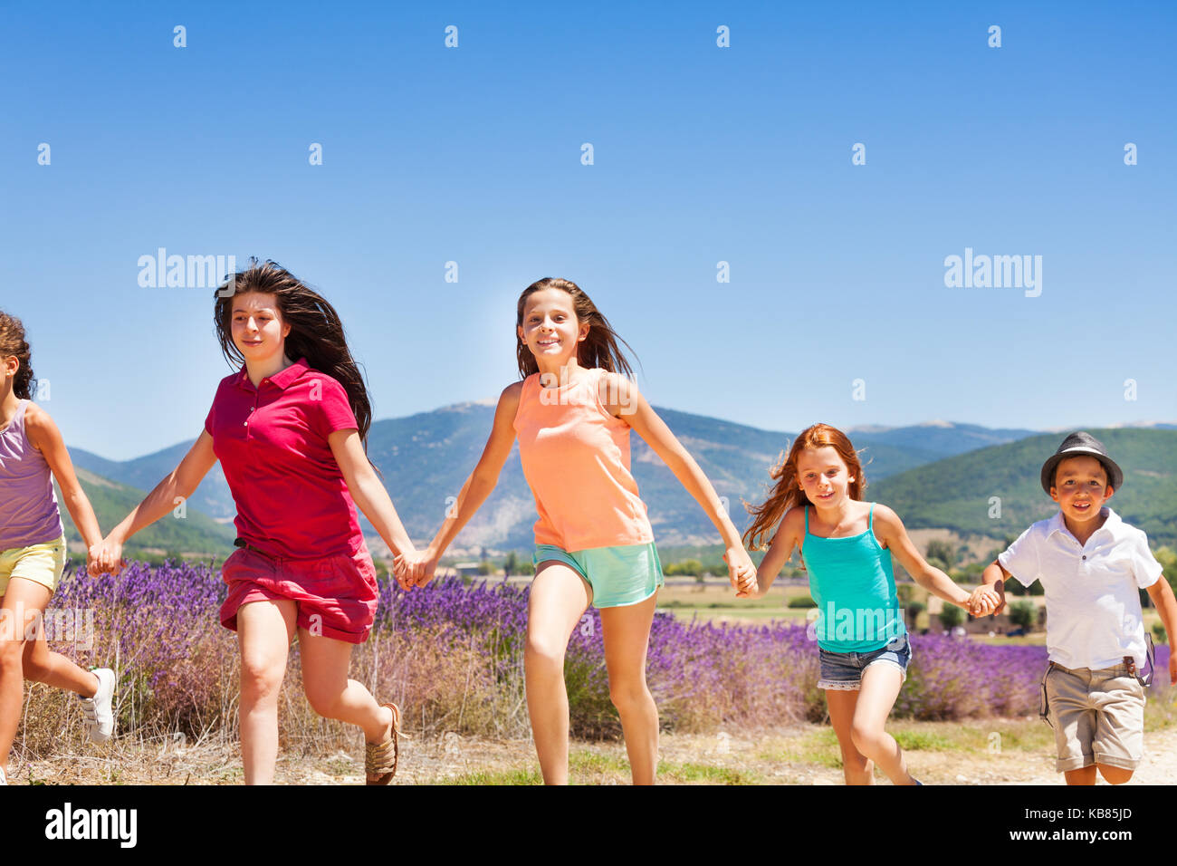 Excited children running together in Provence Stock Photo - Alamy