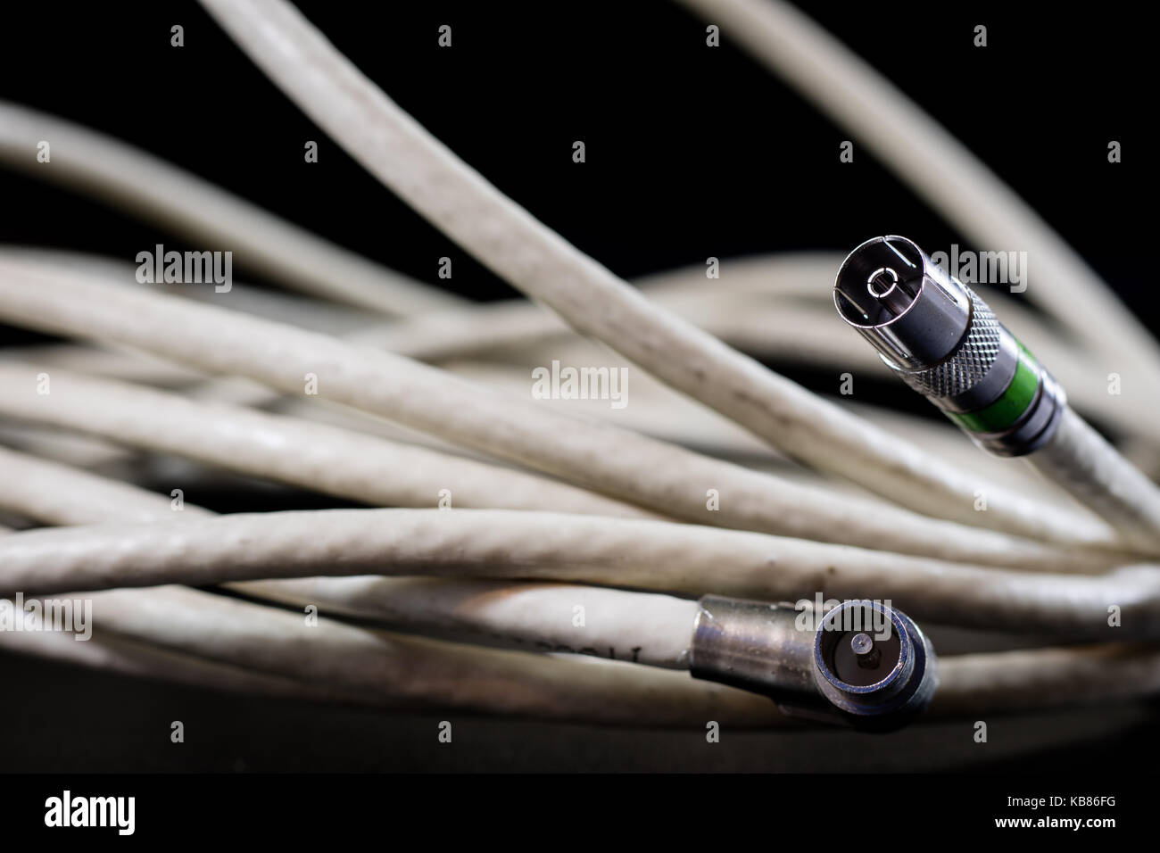 Old entangled cables, electronics and old cable connectors on a black ...