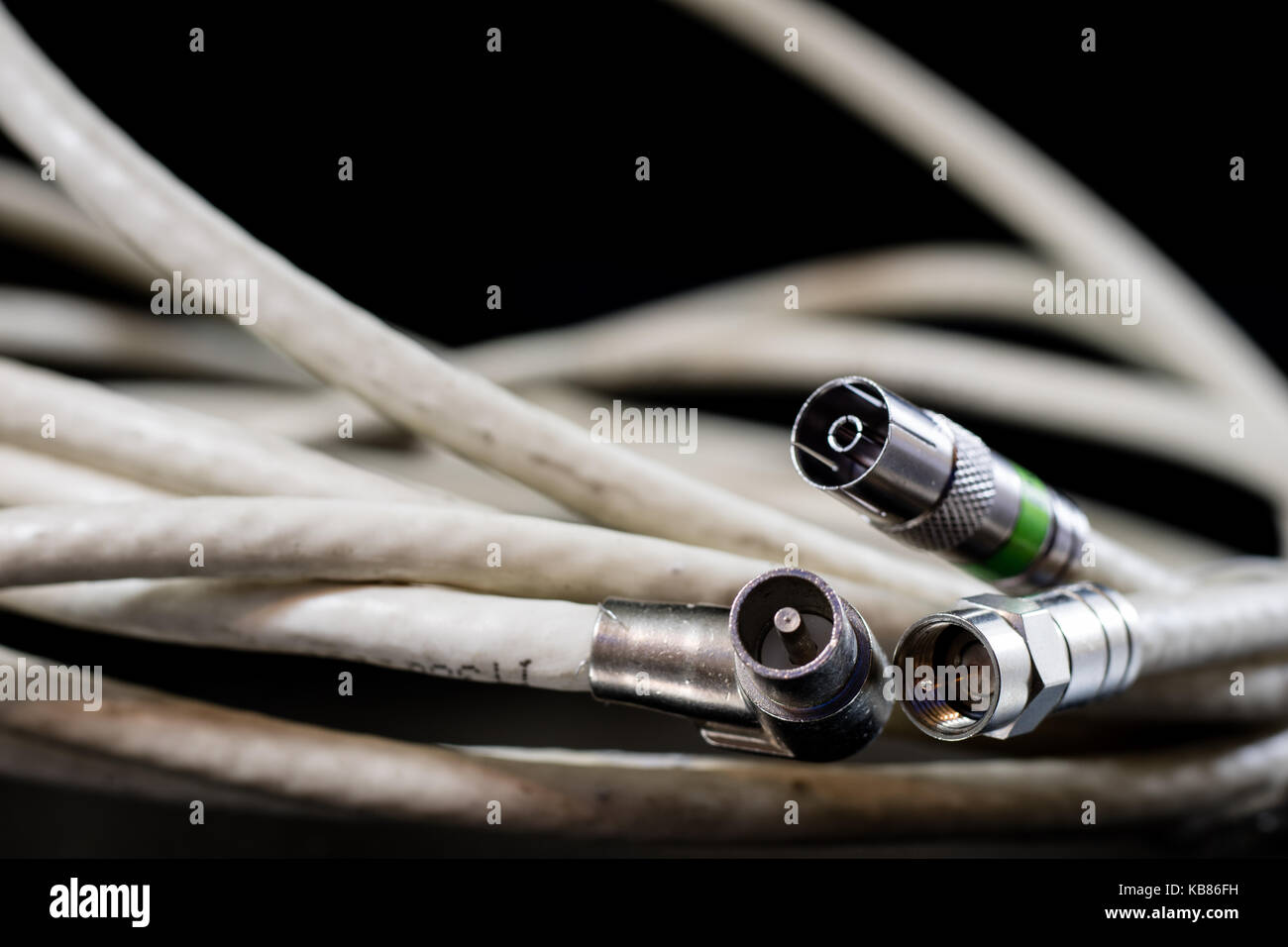 Old entangled cables, electronics and old cable connectors on a black ...