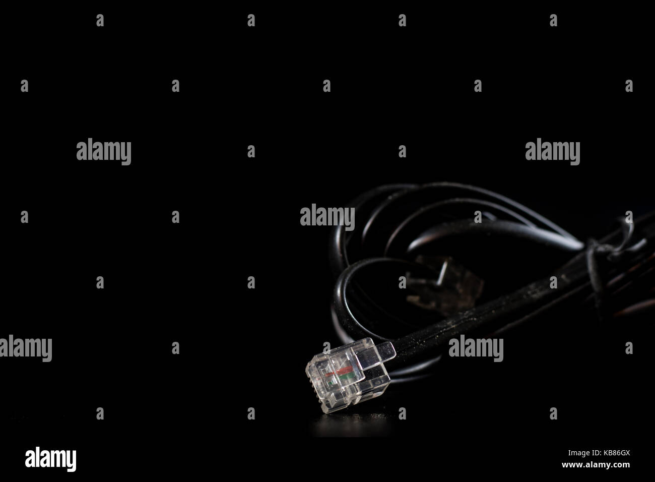 Old entangled cables, electronics and old cable connectors on a black ...