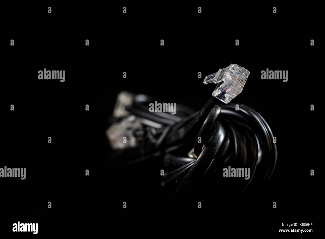 Old entangled cables, electronics and old cable connectors on a black ...