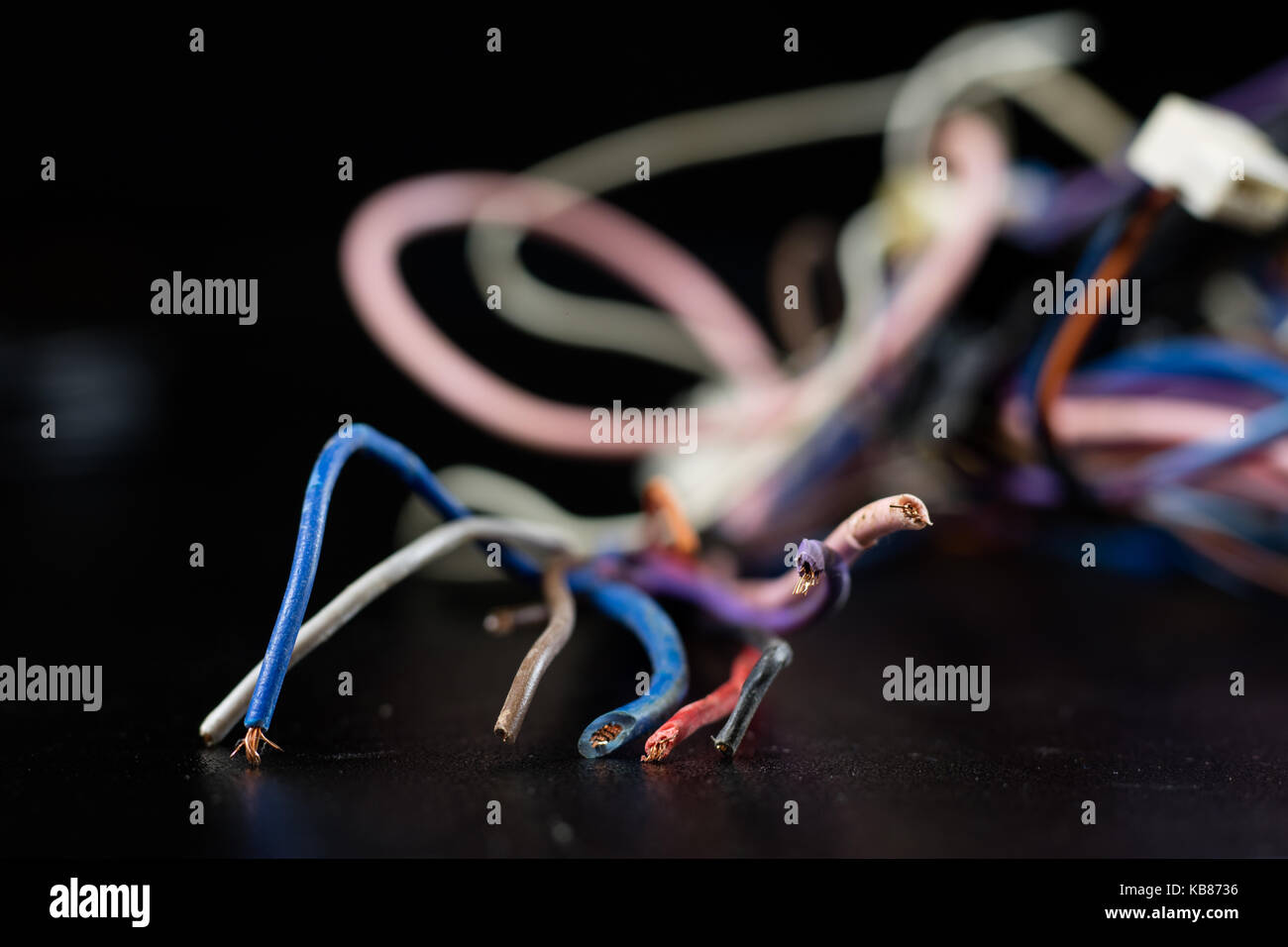 Old entangled cables, electronics and old cable connectors on a black ...