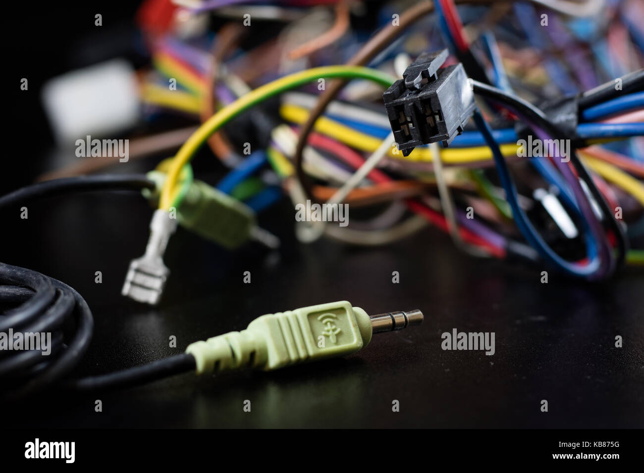 Old entangled cables, electronics and old cable connectors on a black ...