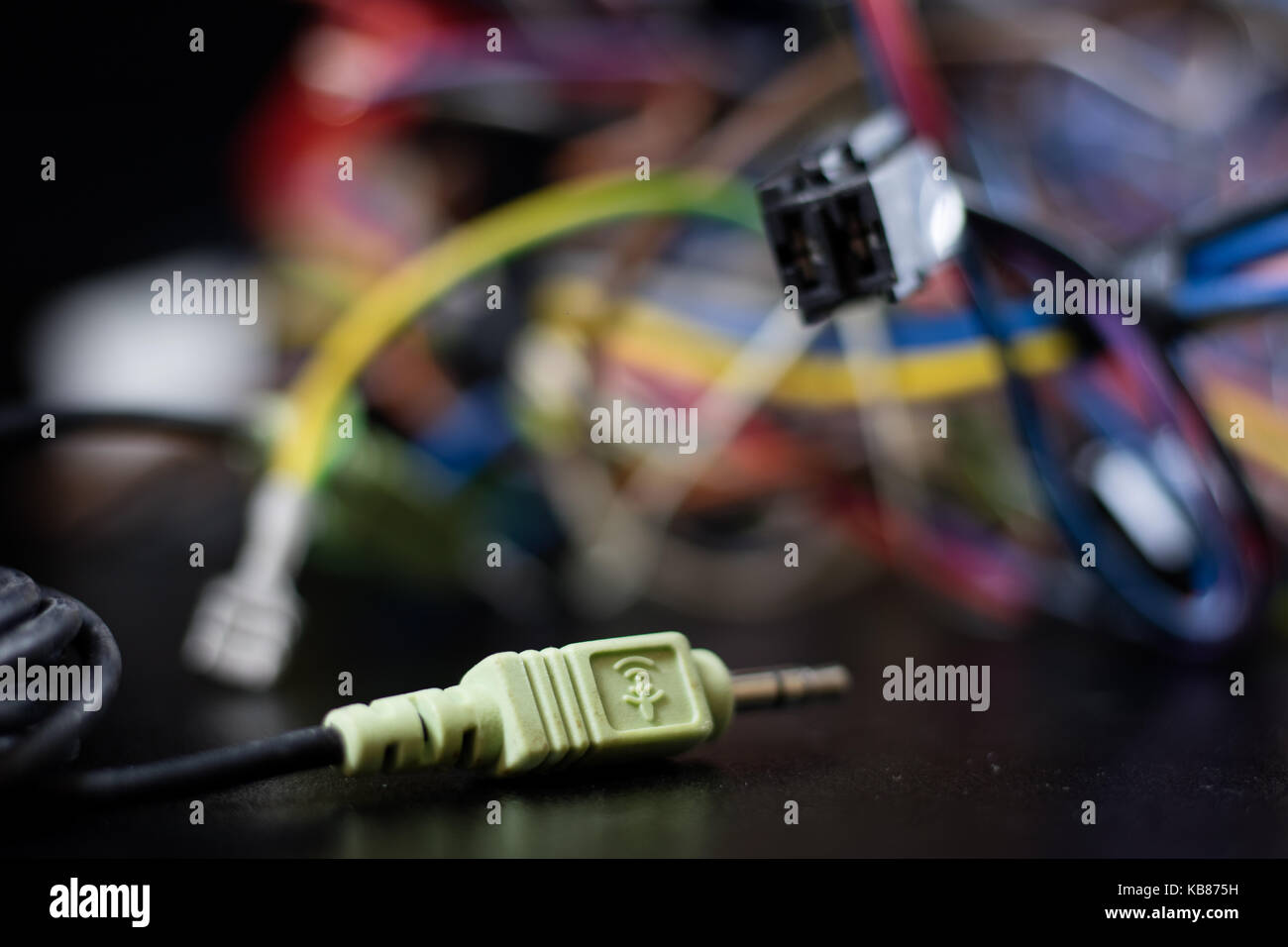 Old entangled cables, electronics and old cable connectors on a black ...