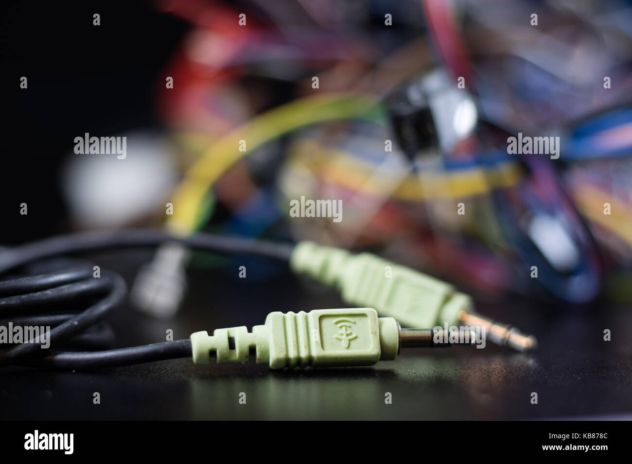Old entangled cables, electronics and old cable connectors on a black ...