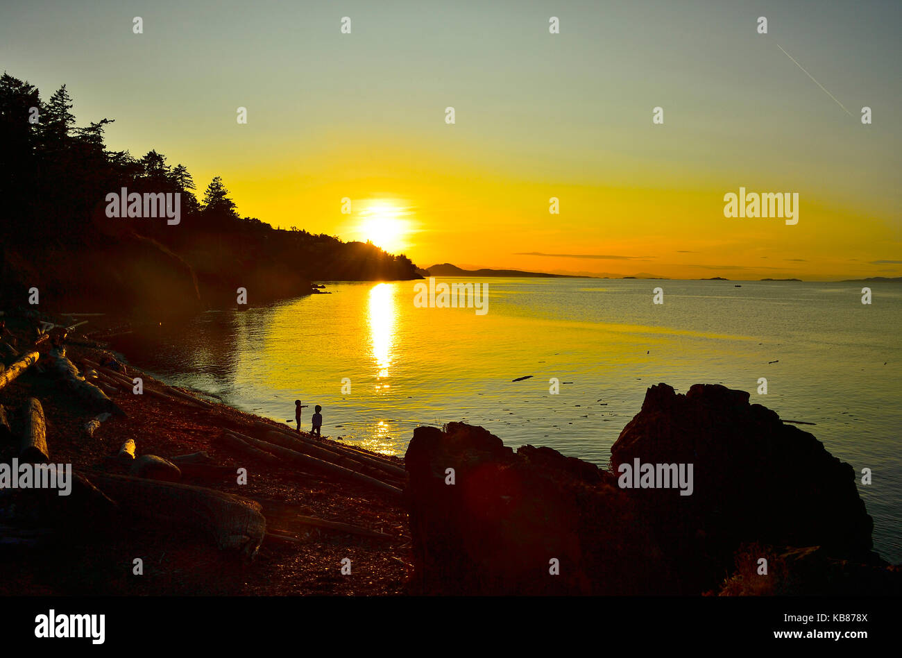 A landscape image of the sunset at Neck Point with two boys playing ...