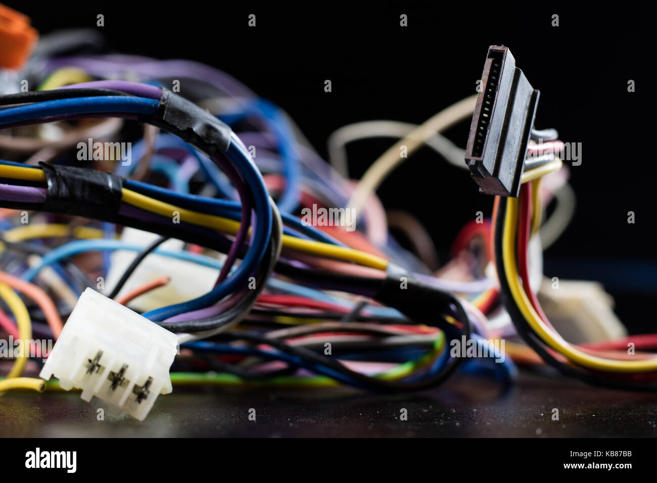 Old entangled cables, electronics and old cable connectors on a black ...