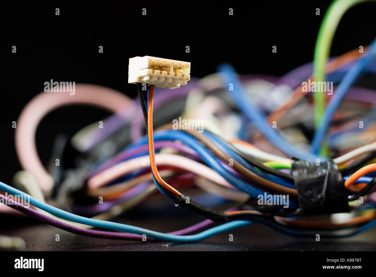 Old entangled cables, electronics and old cable connectors on a black ...