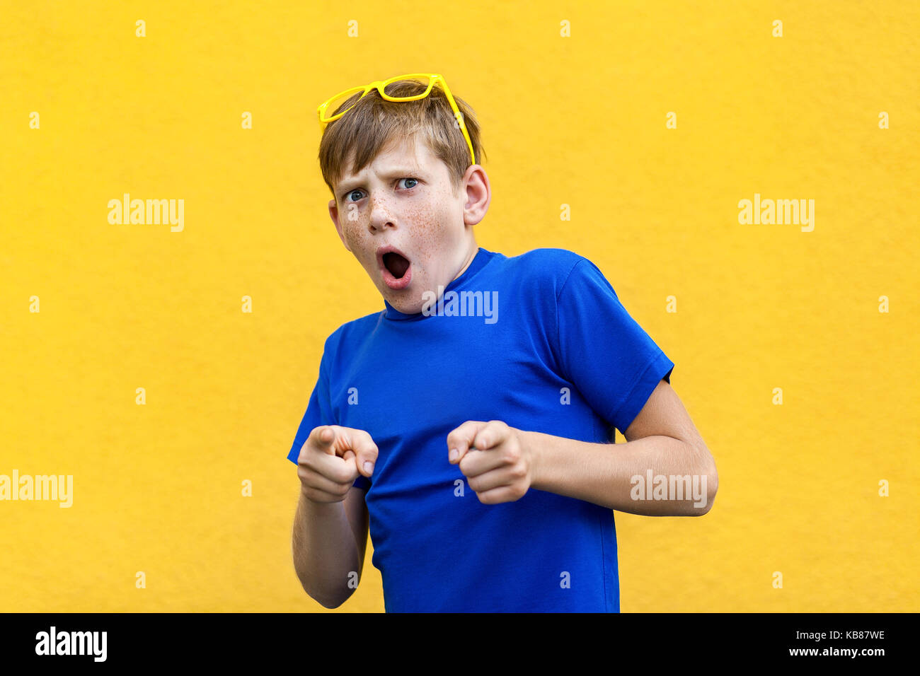 Portrait of scared freckled boy. Pointing fingers at camera and open ...