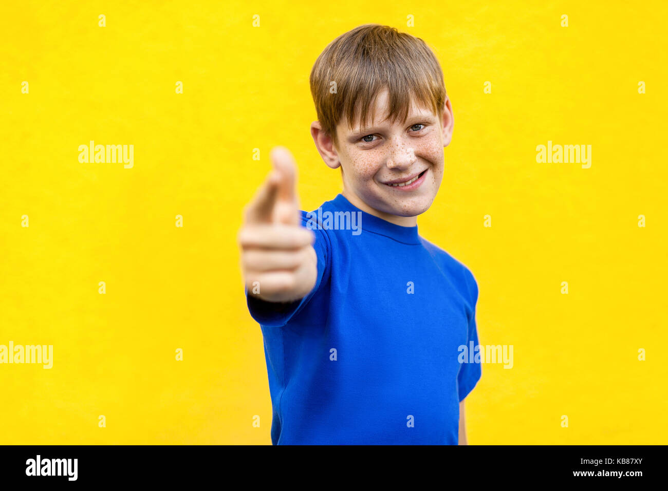 Happiness boy thumbs up, looking at camera and toothy smile. Studio ...