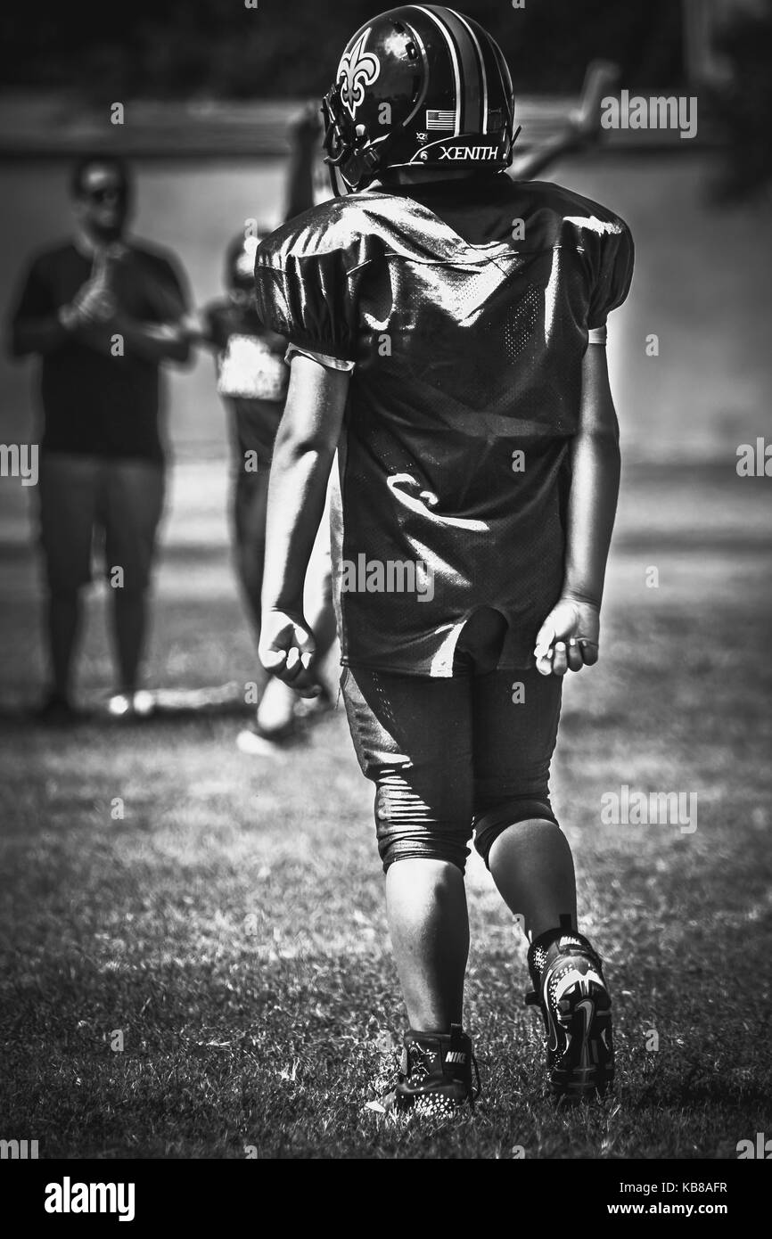 Young football player walking away after touchdown Stock Photo - Alamy