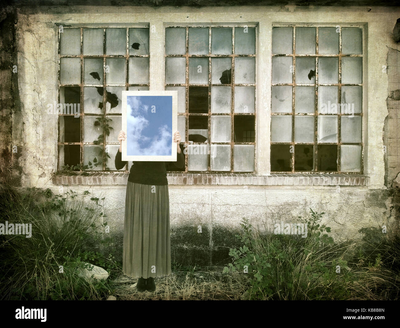 Hope in desolation. Woman with mirror reflecting blue sky Stock Photo ...