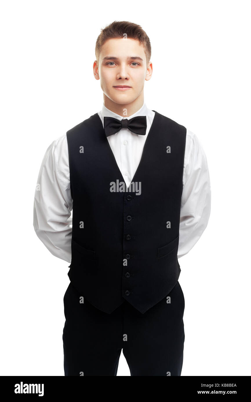 Portrait of young smiling waiter standing with hands behind his back ...
