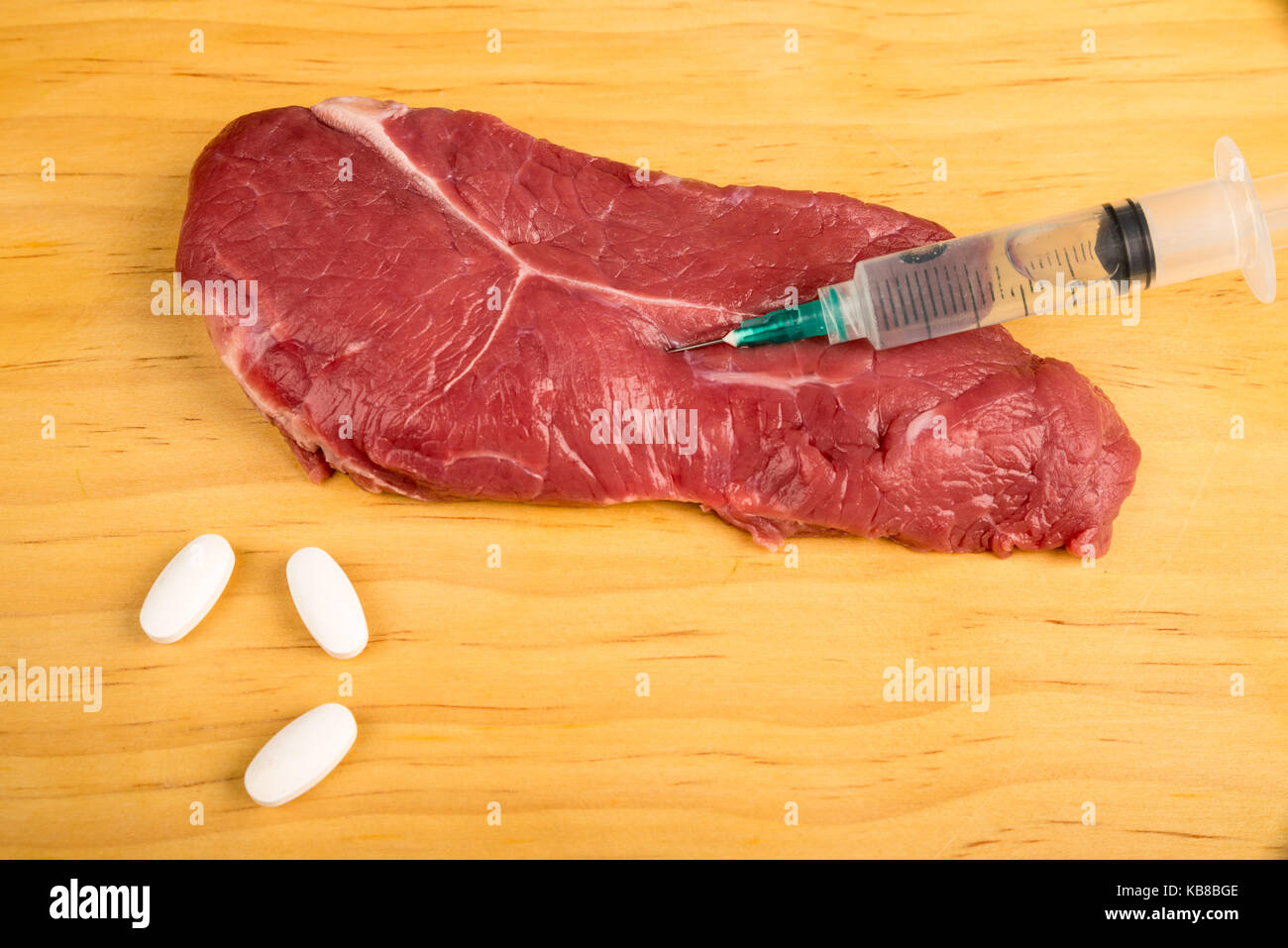 Hormones being injected in a beef steak, a conceptual food manipulation ...