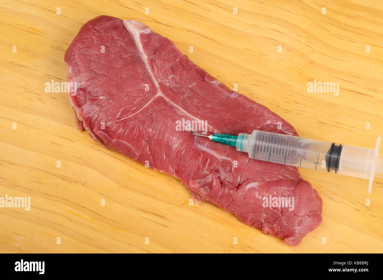 Hormones being injected in a beef steak, a conceptual food manipulation ...