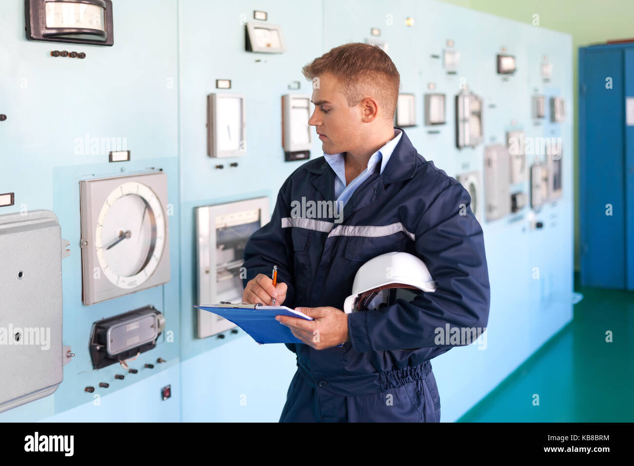Portrait of young engineer taking notes at control room Stock Photo - Alamy