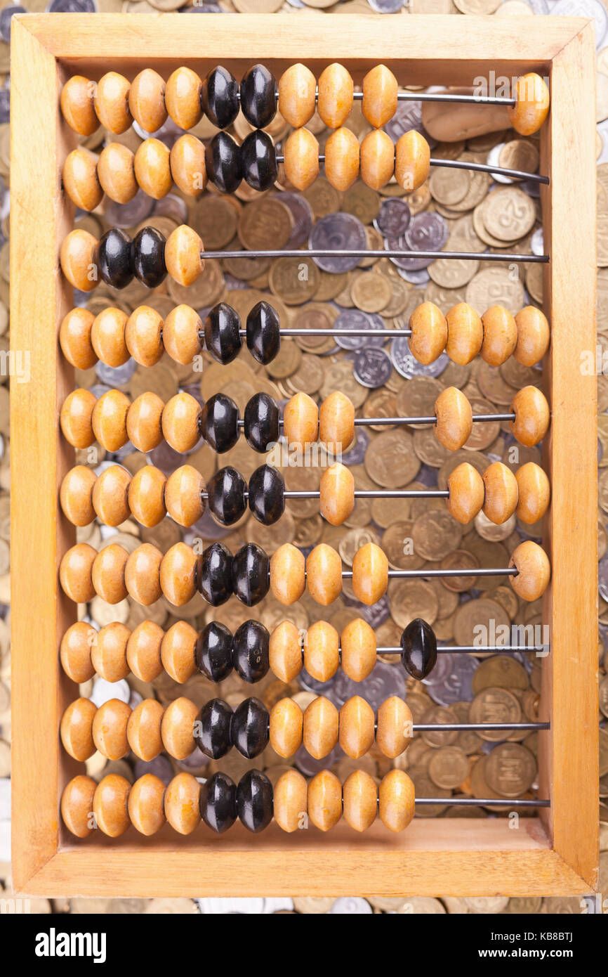 Accounting abacus and heap of coins Stock Photo - Alamy