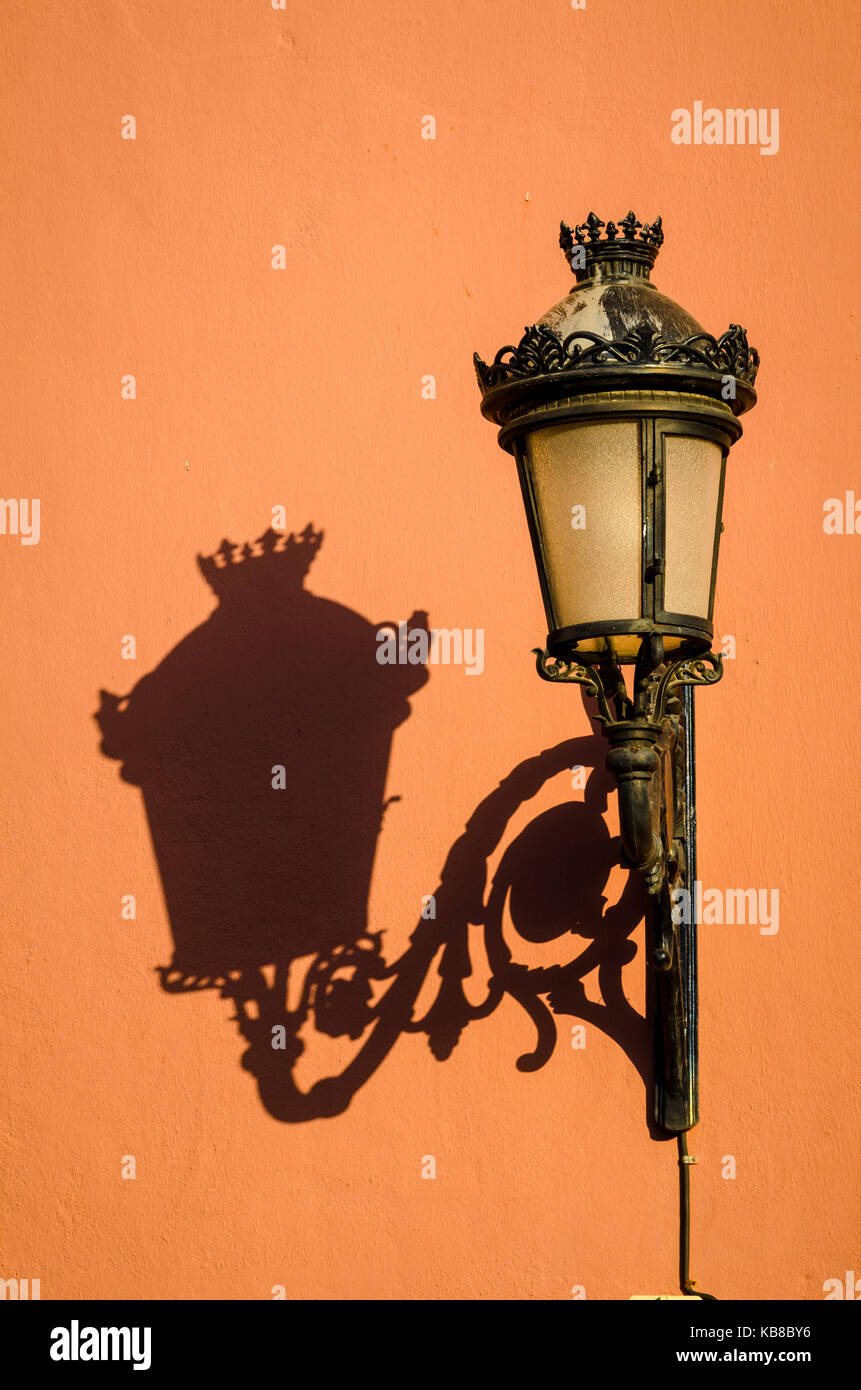 Cast irons street light casting a shadow on a Mediterranean old town ...