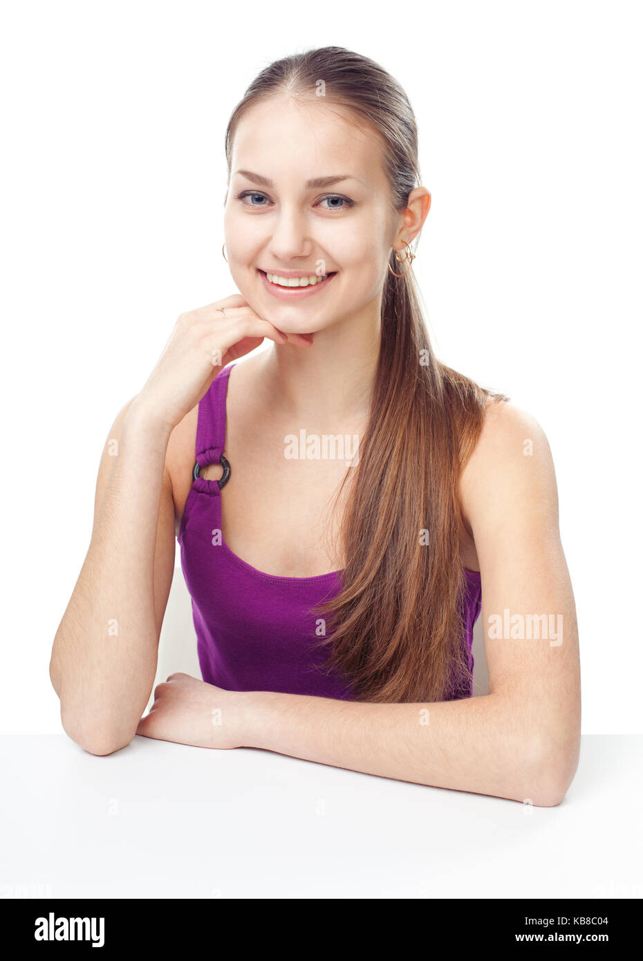 Portrait of pretty young girl sitting at table isolated on white ...