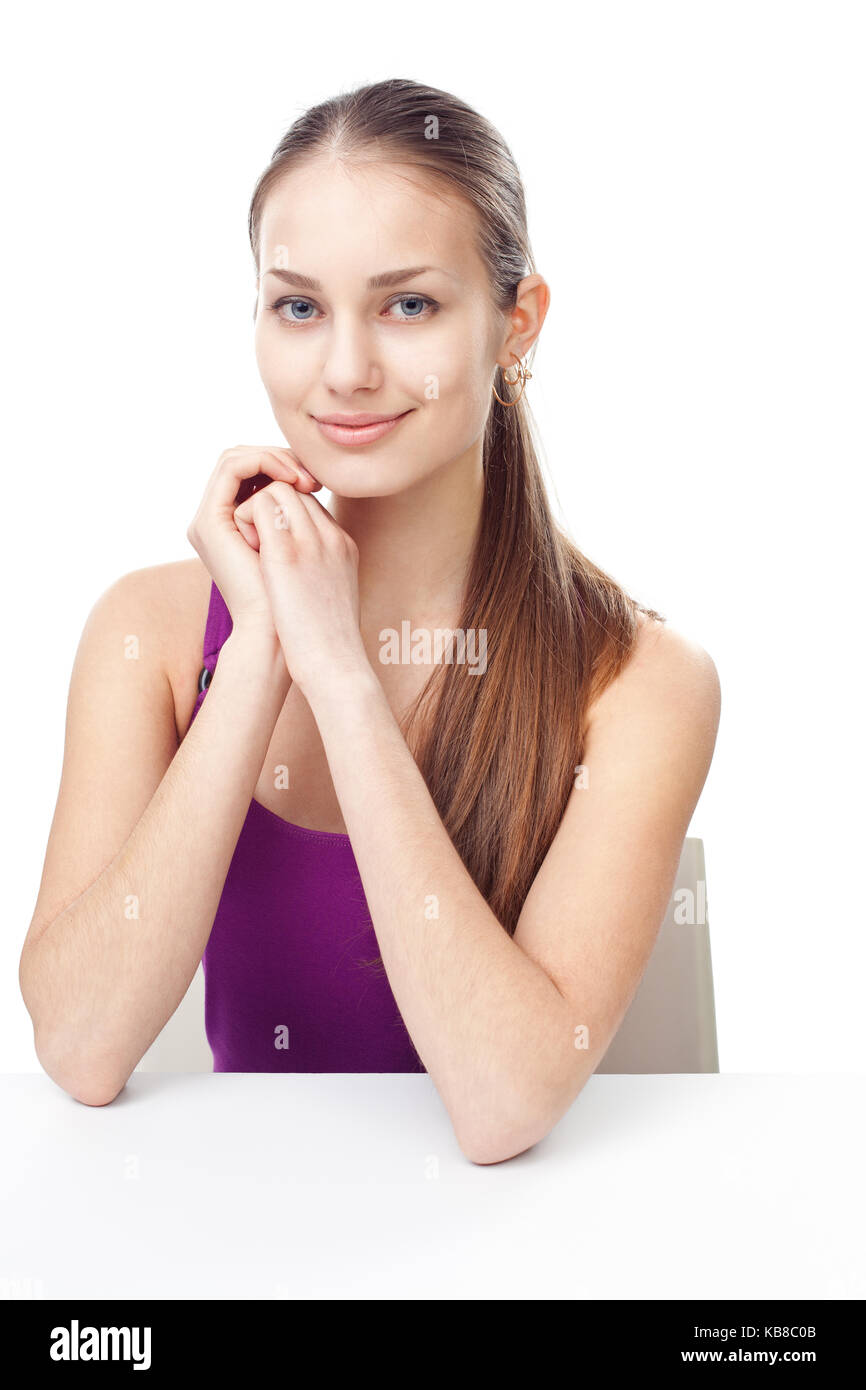 Portrait of pretty young girl sitting at table isolated on white ...
