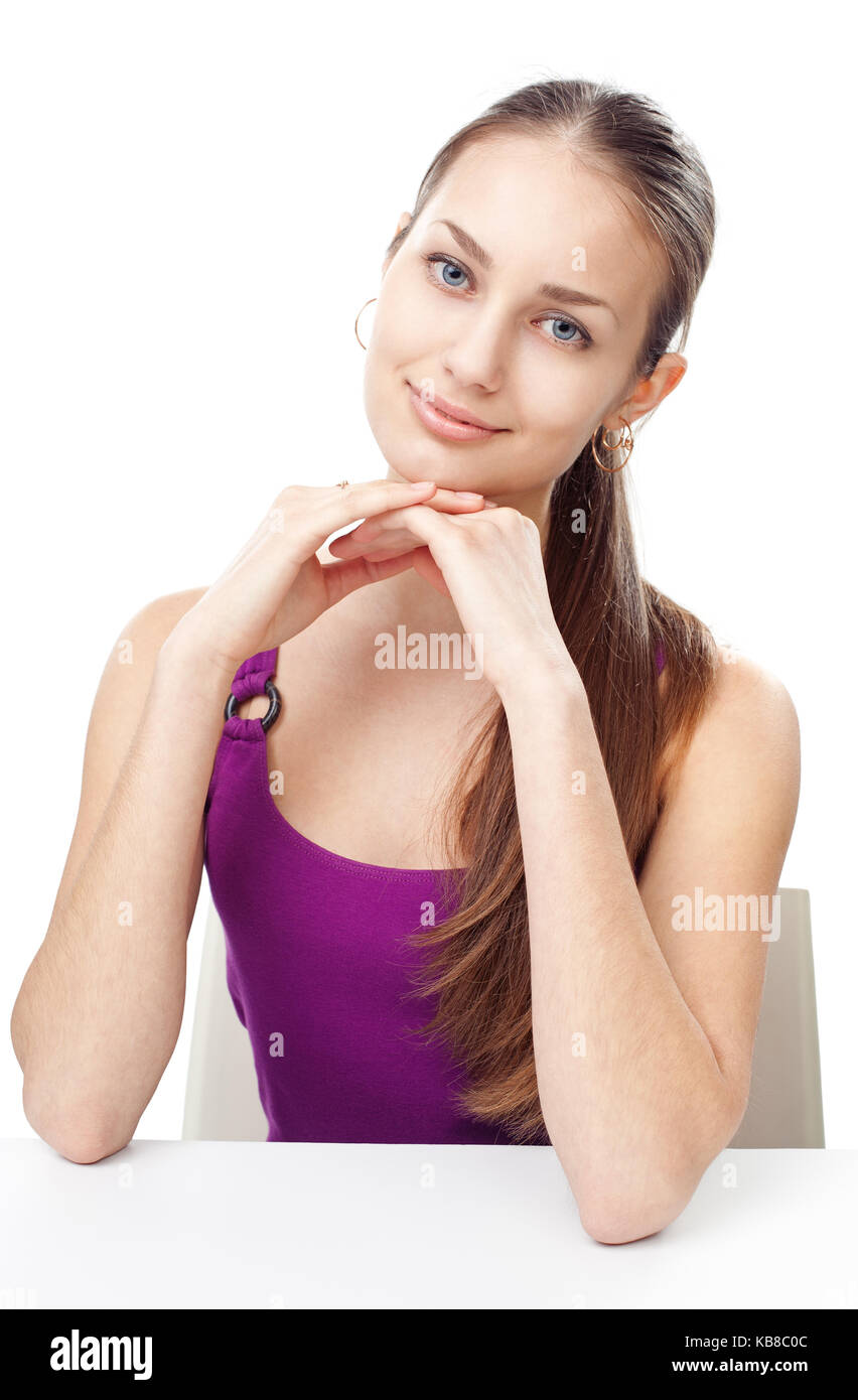 Portrait of pretty young girl sitting at table isolated on white ...