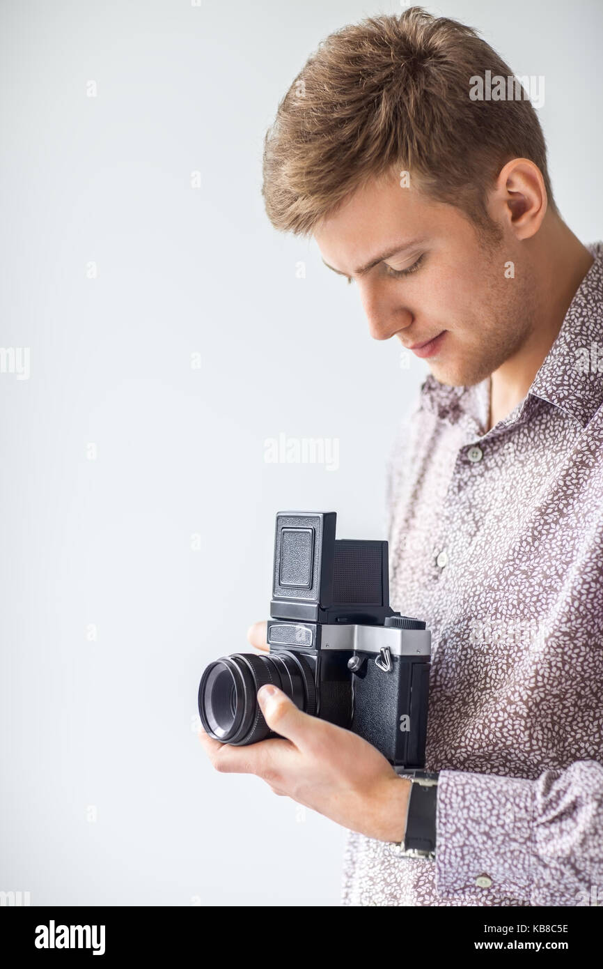 Portrait of handsome man with old medium format camera in studio Stock ...