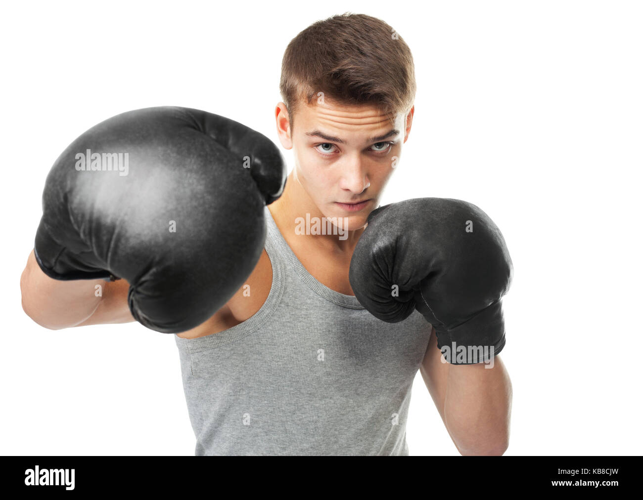 Portrait of young boxer throwing a punch at the camera isolated on ...