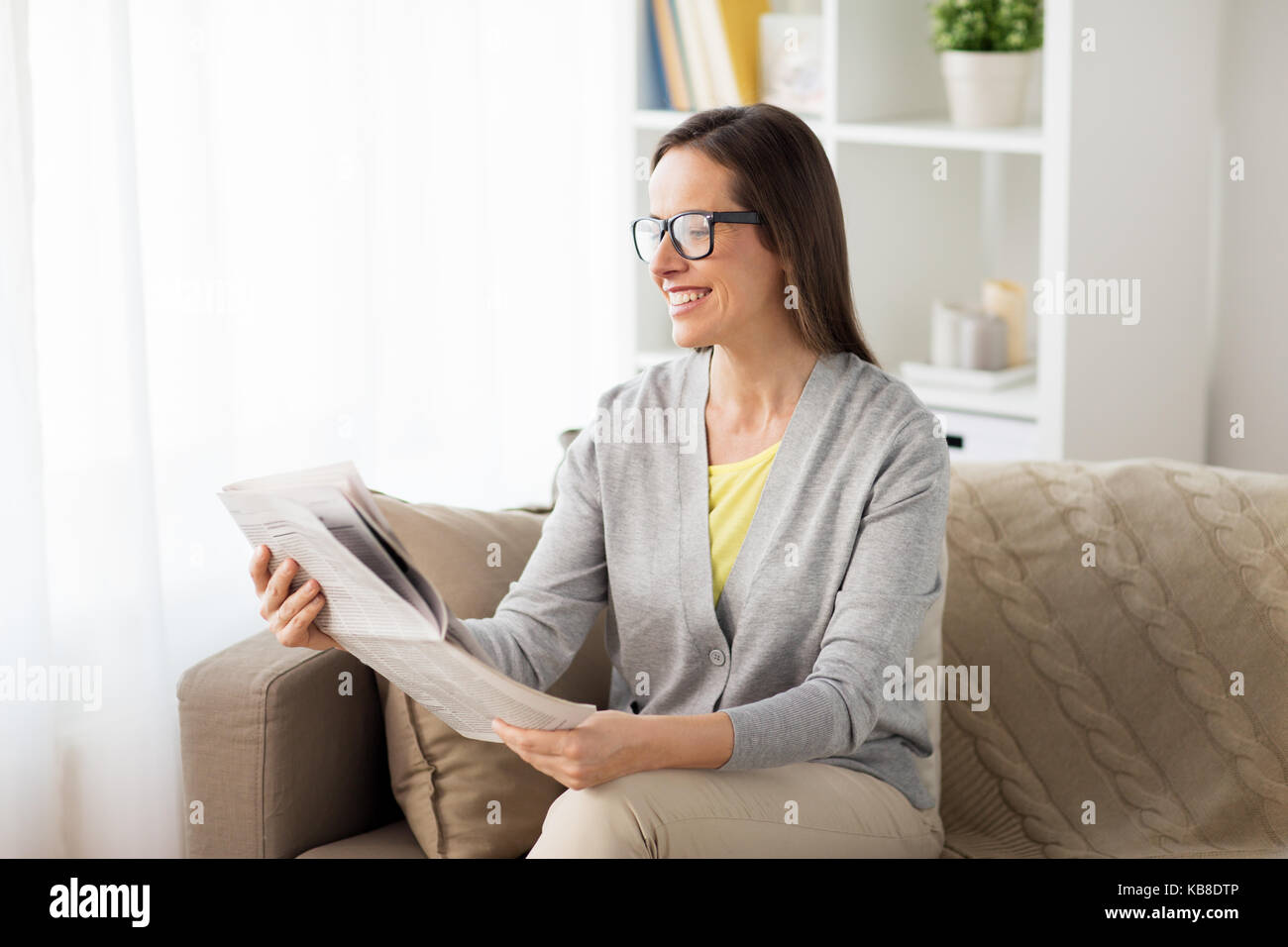 happy woman reading newspaper at home Stock Photo - Alamy