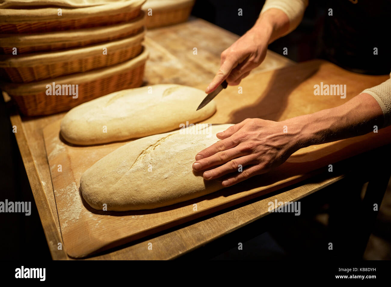 baker making bread and cutting dough at bakery Stock Photo - Alamy