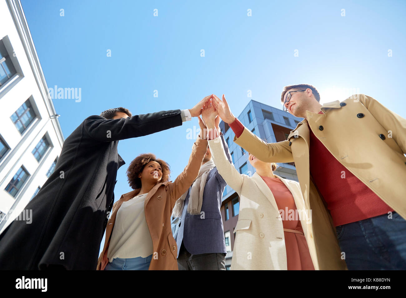 group of happy people making high five in city Stock Photo - Alamy