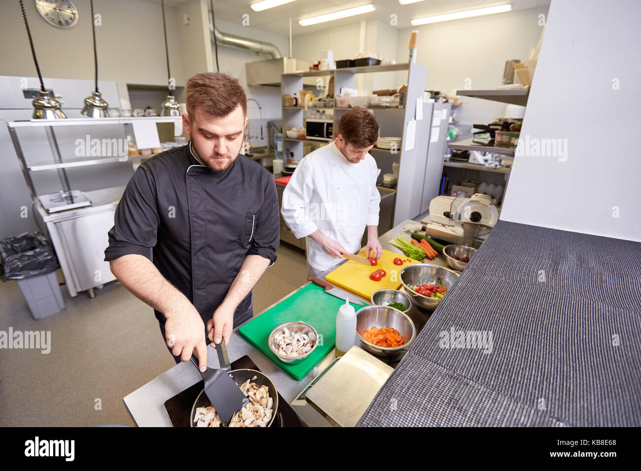 chef and cook cooking food at restaurant kitchen Stock Photo - Alamy