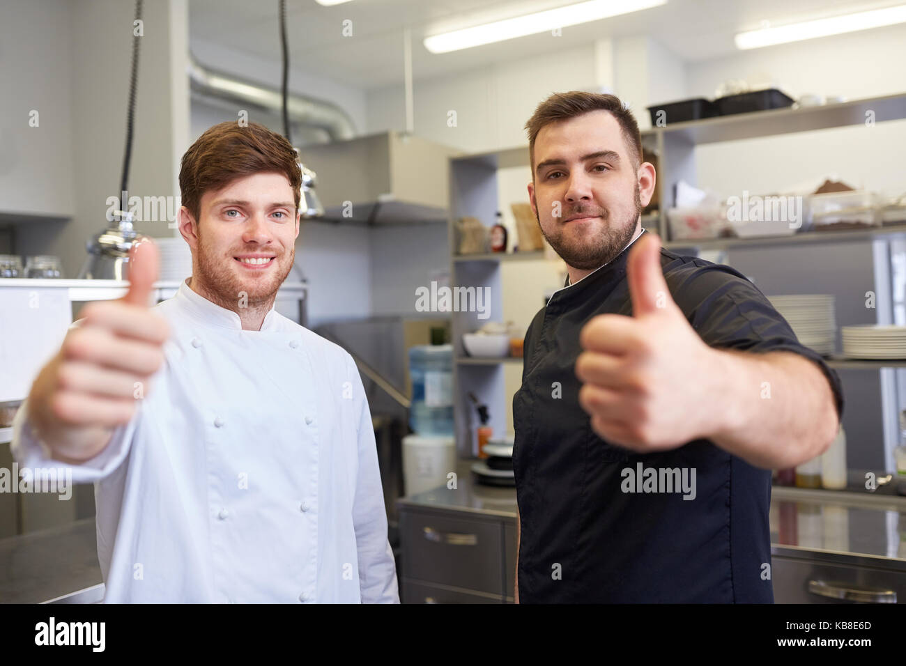 chefs at restaurant kitchen showing thumbs up Stock Photo - Alamy