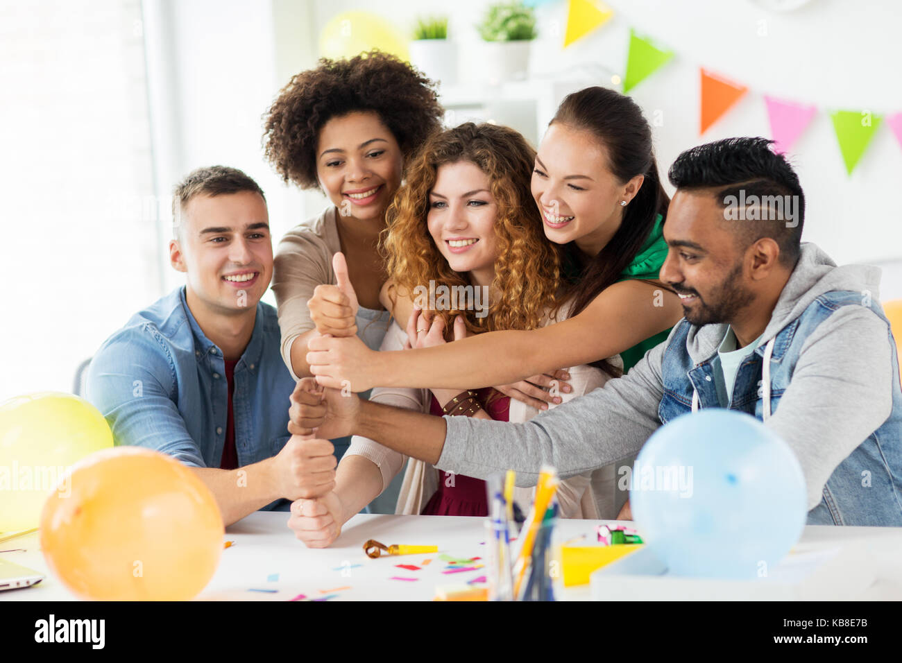 happy team at office party showing thumbs up Stock Photo - Alamy