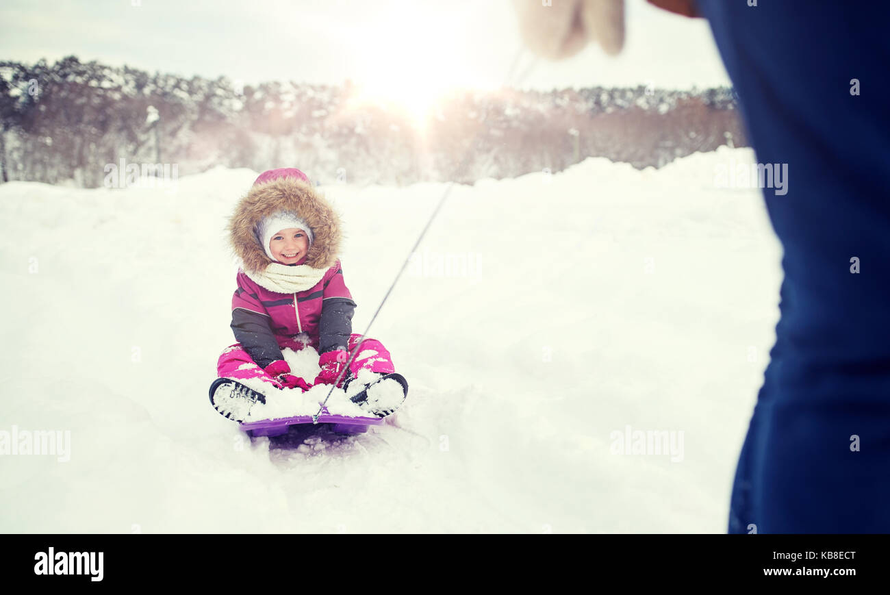 parent carrying happy little kid on sled in winter Stock Photo - Alamy
