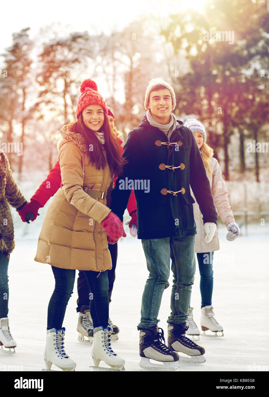 happy friends ice skating on rink outdoors Stock Photo - Alamy