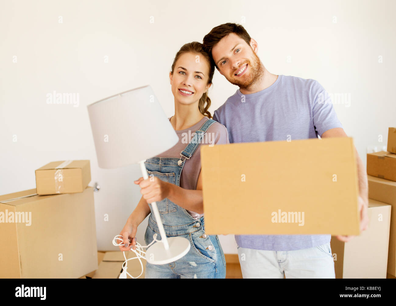 couple with boxes and lamp moving to new home Stock Photo - Alamy