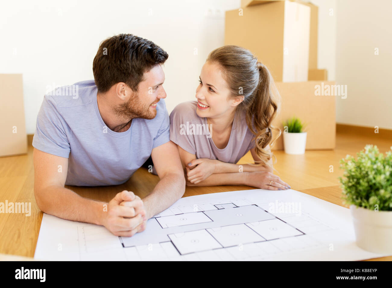 couple with boxes and blueprint moving to new home Stock Photo - Alamy
