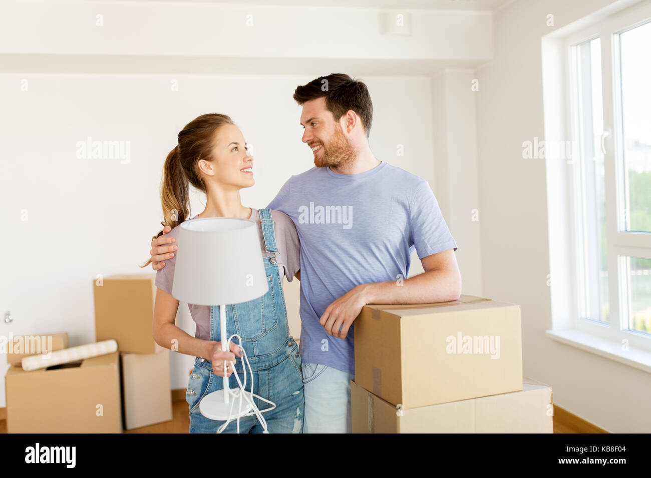 couple with boxes and lamp moving to new home Stock Photo - Alamy