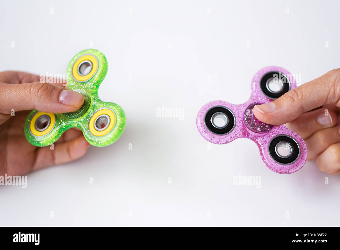 close up of two hands playing with fidget spinners Stock Photo - Alamy