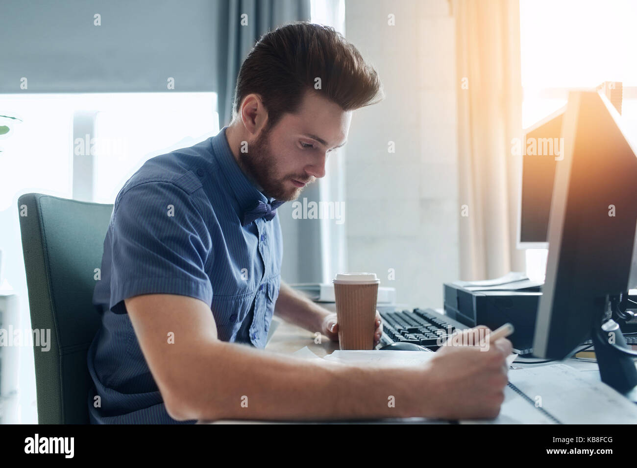 creative male office worker with coffee writing Stock Photo - Alamy