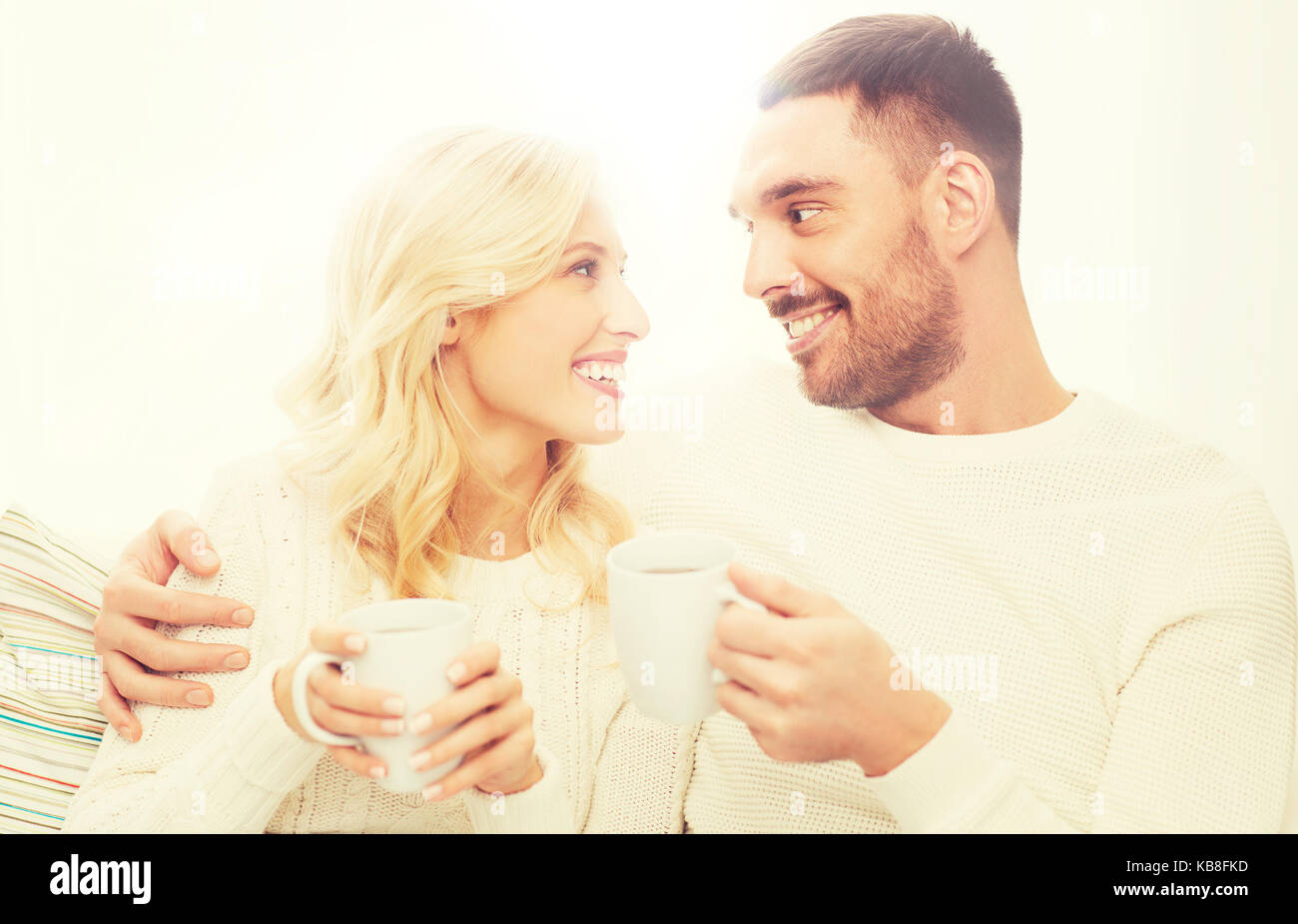happy couple with cups drinking tea at home Stock Photo - Alamy