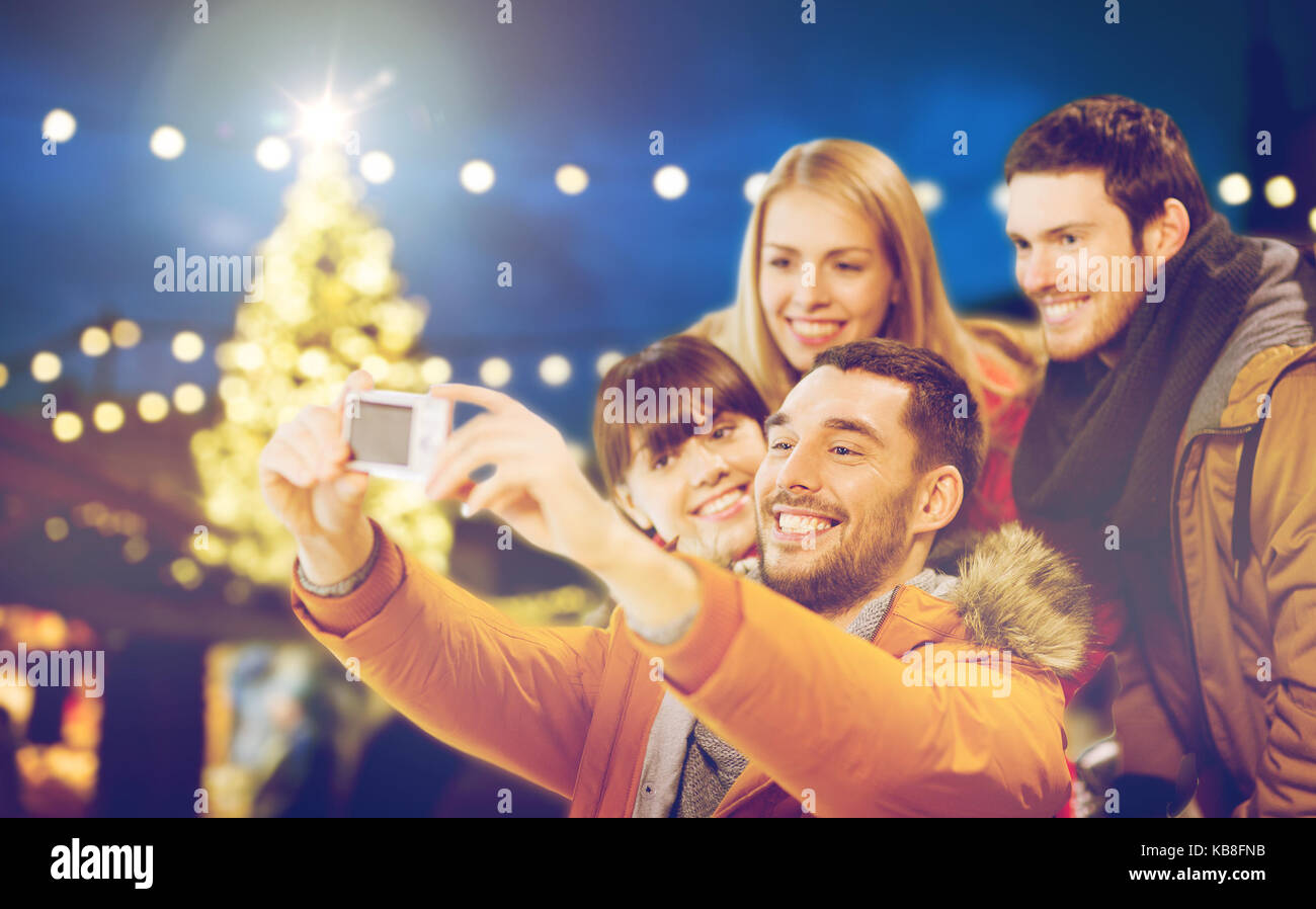happy friends with camera taking christmas selfie Stock Photo - Alamy