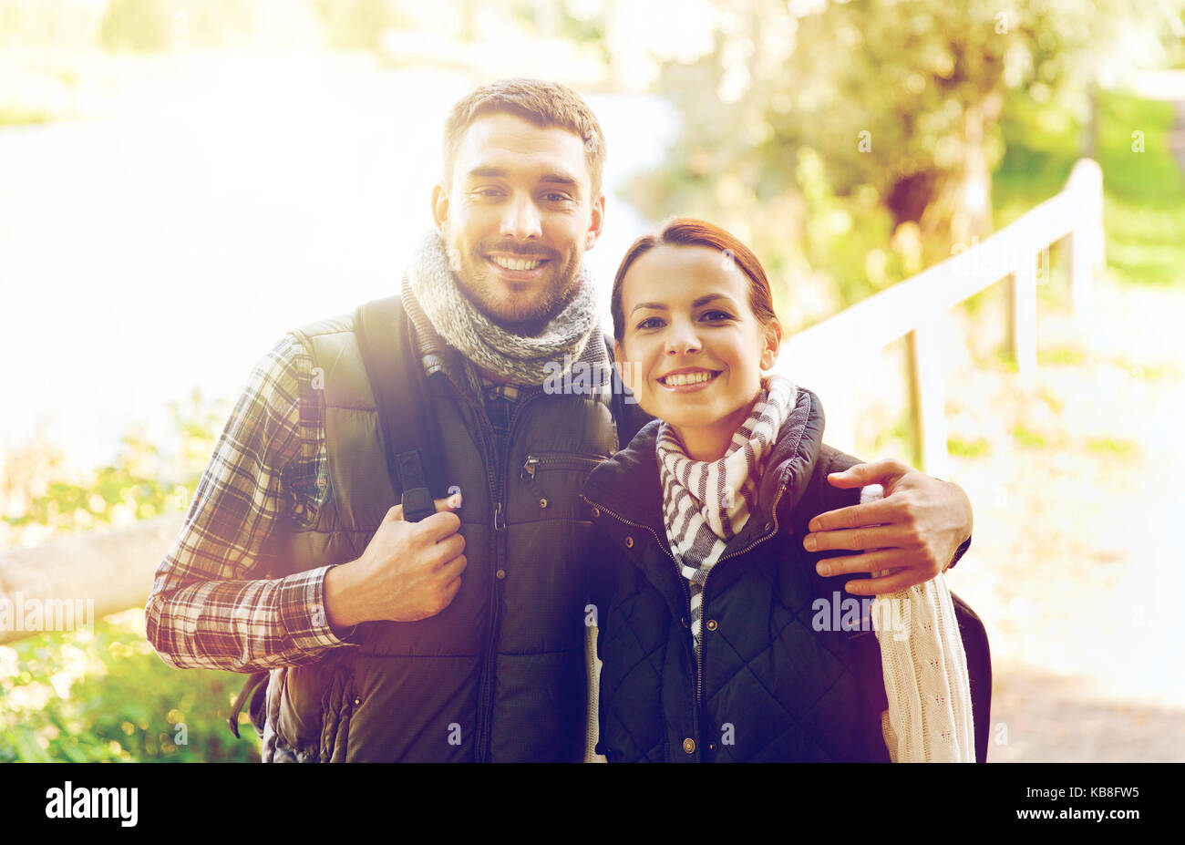 happy couple with backpacks hiking and hugging Stock Photo - Alamy