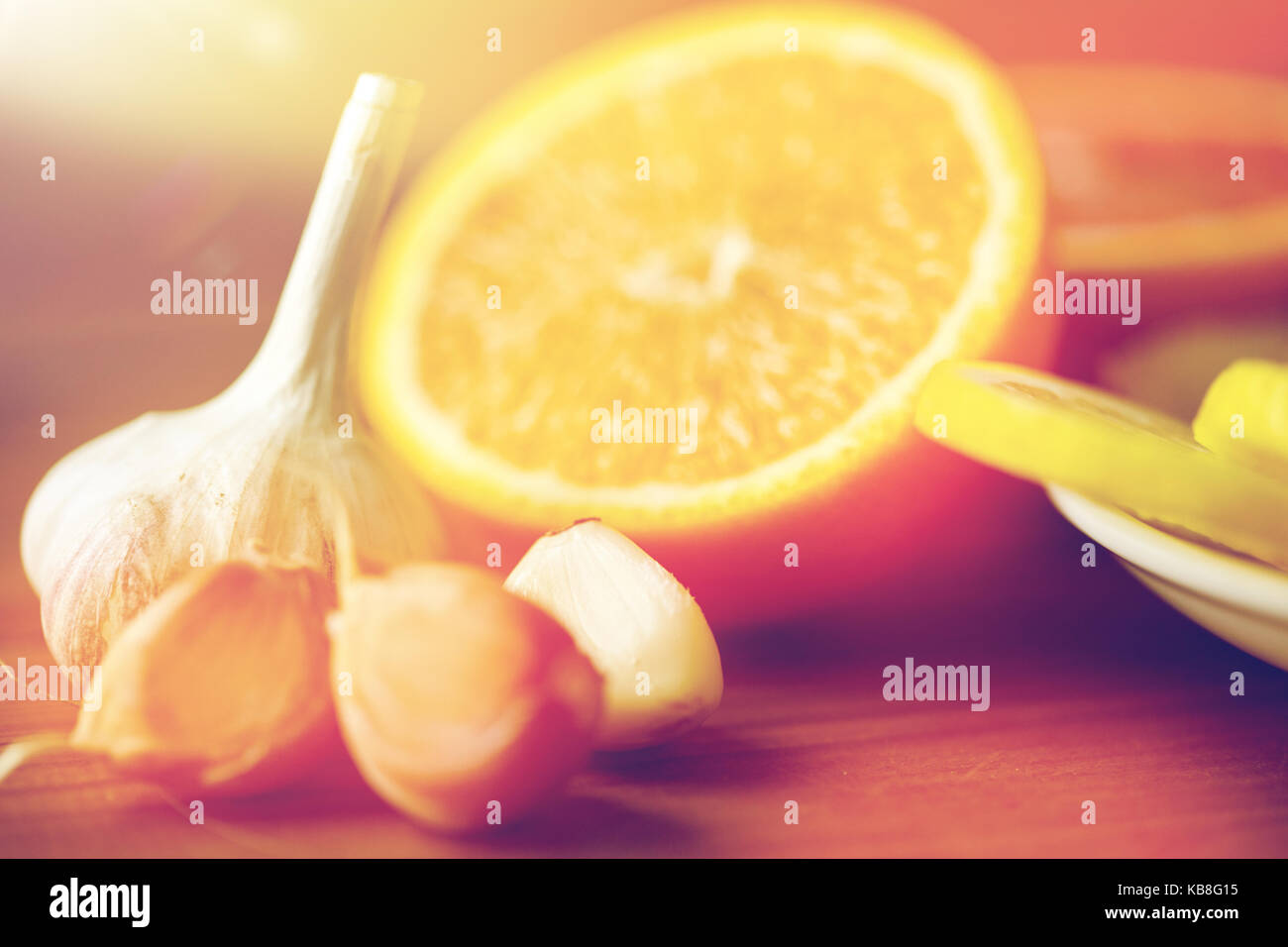 close up of garlic and orange on wooden table Stock Photo - Alamy