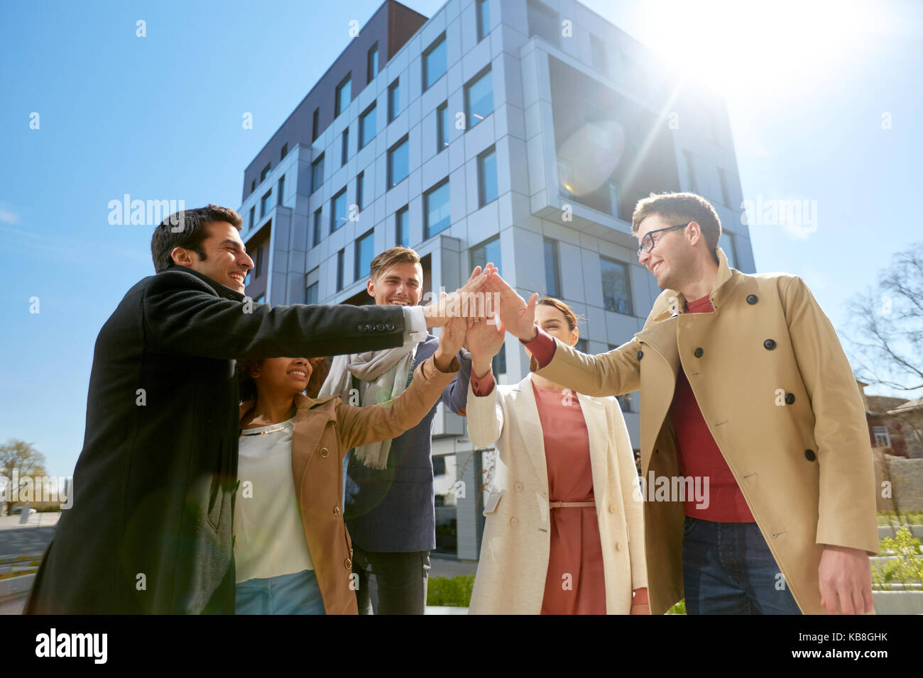 group of happy people making high five in city Stock Photo - Alamy