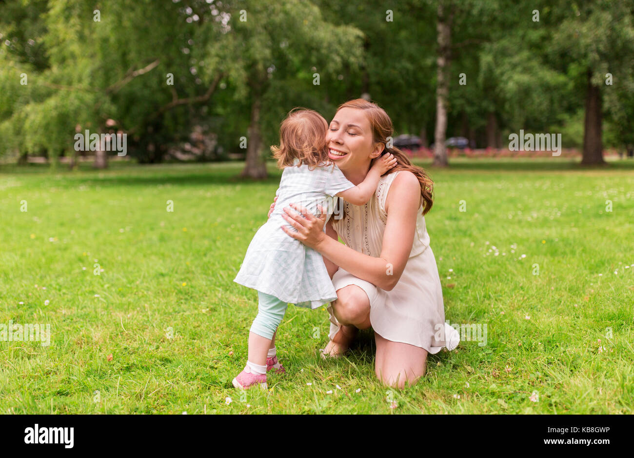 happy mother hugging baby girl at summer park Stock Photo - Alamy